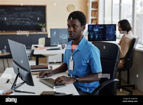 Young Serious African American Programmer Sitting In Front Of Computer