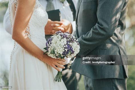 Bride And Groom Saying Vows During Wedding Ceremony Outdoors High Res