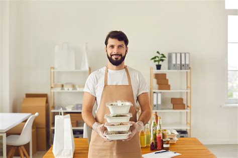 음식 용기에 준비 테이크 아웃 점심 주문을 들고 앞치마 유니폼을 입고 웃는 카페 노동자 식사 음식에 대한 스톡 사진 및 기타