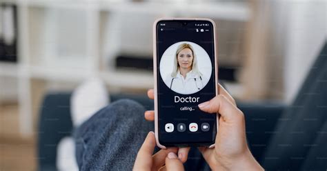 가상 의료 상담 알아볼 수 없는 여자 집에서 소파에 앉아 핸드폰으로 화상 통화를 통해 의사에게 전화 금발의 성숙한 여성 의사의 사진으로 스마트폰 화면을 닫습니다 사진