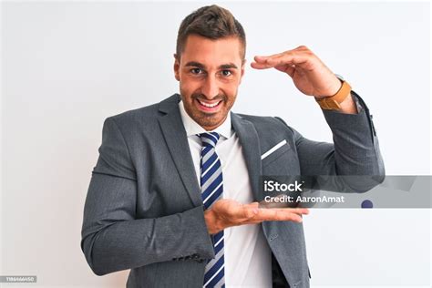 크고 큰 간판을 보여주는 손으로 고립 된 배경 몸짓을 통해 양복과 넥타이를 매고 있는 젊은 잘 생긴 사업가 기호를 측정 합니다 카메라를 바라보며 웃고 있습니다 측정 개념