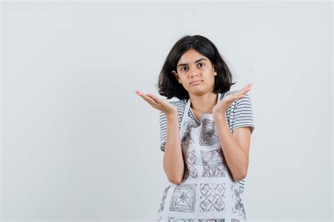 T 셔츠에 무기력 제스처를 보여주는 어린 소녀 무료 사진