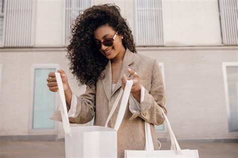 Nice Young African Girl With Wavy Hair Looks At Contents Of Her Bag