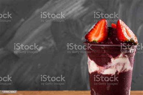 브라질 냉동 아사이 베리 아이스크림 스무디는 딸기와 응축 우유플라스틱 컵에 나무 책상과 회색 여름 배경에 메뉴 및 소셜 미디어에 대한 전면 보기 0명에 대한 스톡 사진 및