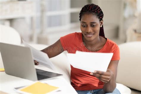 Black Young Freelancer Woman Working With Documents And Laptop At Home