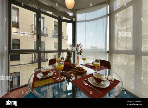 Circular Glass Dining Table With Fresh Fruit And Orange Juice With A