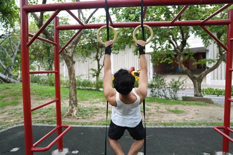 Asian Man Practicing Gymnastics Doing Gymnastics Bar And Hoop Exercises