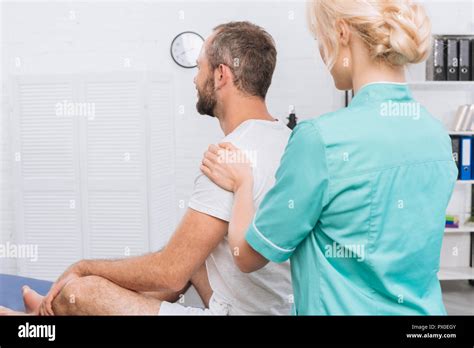 Side View Of Female Massage Therapist Doing Massage To Patient On