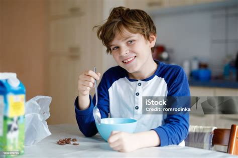 아침 이나 점심 시리얼을 먹는 행복 한 작은 금발 아이 소년 어린이를위한 건강한 식사 우유와 뮤즐리와 함께 아침 식사를 하는