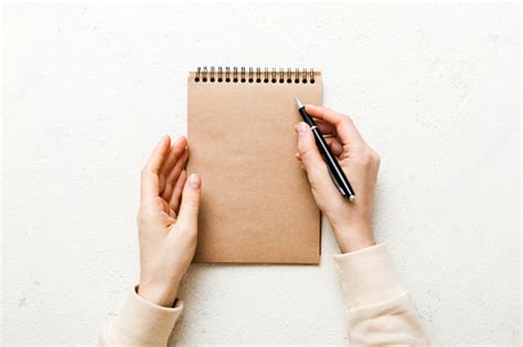 공책에 연필을 쓰고 있는 여자 손 사무실 테이블에서 일하는 여자 연필과 스케치북을 들고 있는 여성 손 모형 컨셉 백인종에 대한