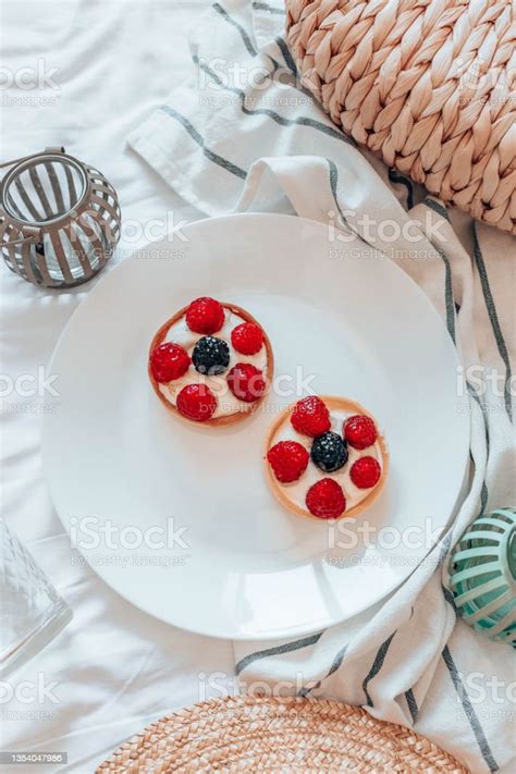 화이트 플레이트에 크림을 채우는 맛있는 라즈베리 타르트 흰색 배경에 신선한 과일 타르트 여름 페이스트리 디저트 세로 사진 방향