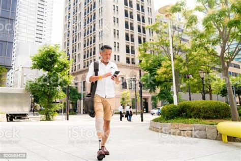 그의 휴대 전화를 사용 하 여 야외 캐주얼 수석 수족 사업가 절단 수술을 받은 사람에 대한 스톡 사진 및 기타 이미지 절단