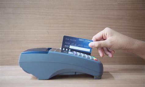 Premium Photo Cropped Hand Scanning Credit Card On Table