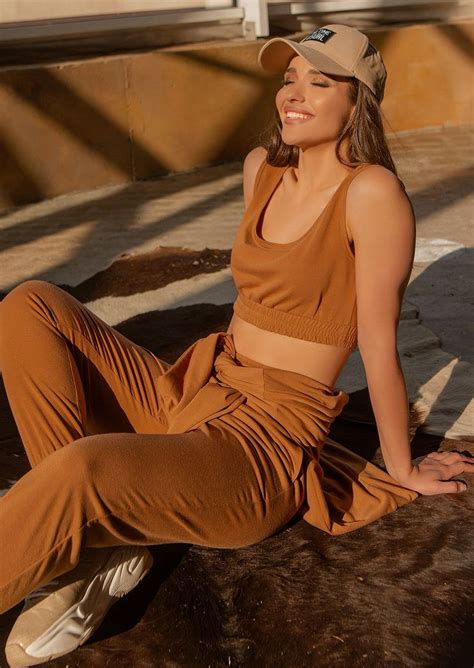 Счастливая красивая девушка в спортивном костюме улыбается и расслабляется после тренировки