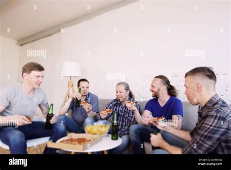 Group Of Men Drinking Beer Eating Pizza Talking And Smiling While