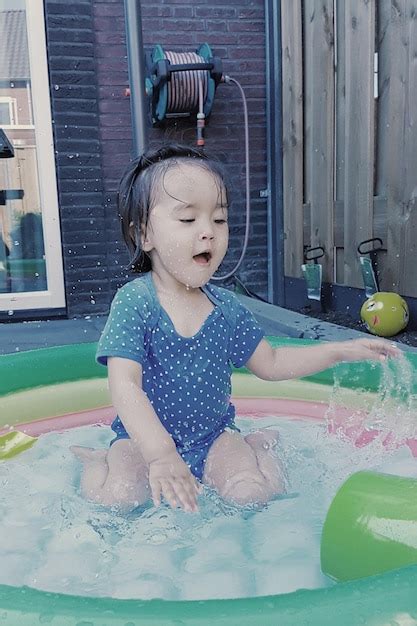 Premium Photo Cute Girl Splashing Water In Wading Pool