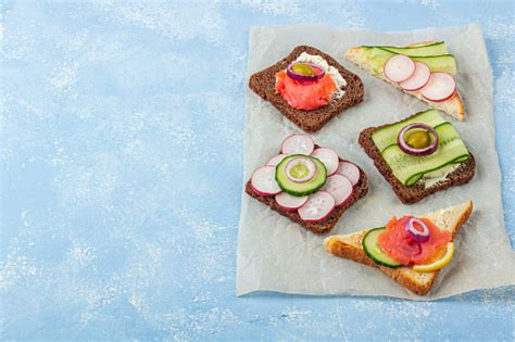 전채 다른 토핑 샌드위치를 엽니 다 파란색 배경에 종이에 연어와 야채 전통 이탈리아 또는 스칸디나비아 간식 건강한 식생활 닫기 텍스트에 대한 공간을 복사 Smorrebrod