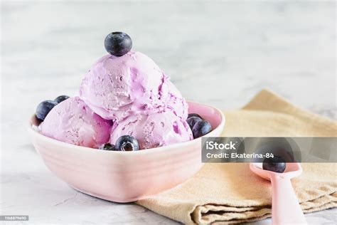 그릇에 블루 베리와 보라색 달콤한 아이스크림 보라색 꽃병에 과일을 곁들인 아이스크림 세 덩어리 프로스팅 소르베의 일부 숟가락에