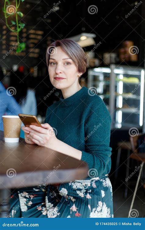 Beautiful Cute Girl In The Cafe Near The Window With Coffee Smiling