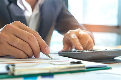 Pebisnis Menganalisis Data Grafik Dengan Laptop Dan Kalkulator Foto