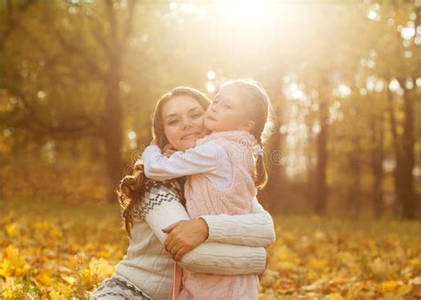 Mother And Daughter Having Fun In The Autumn Park Among The Fall Stock