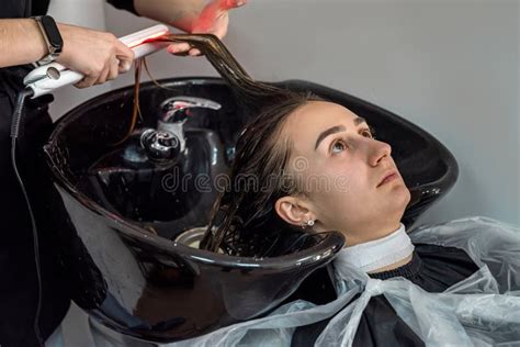 Girl Sits In A Salon Where Her Master Colorist Washes Her Head And Hair