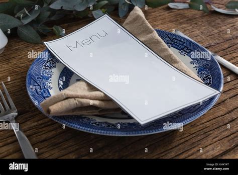 Close Up Of Plate With Fork Butter Knife Napkin And Menu Card On
