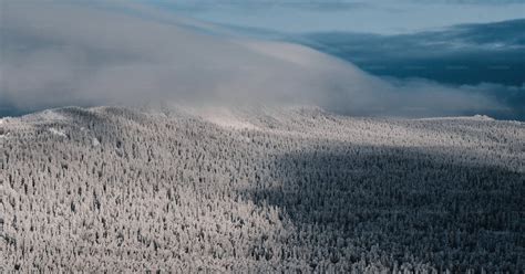 푸른 하늘을 배경으로 눈과 구름으로 덮인 Taganay 산 사슬의 겨울 풍경 사진 Unsplash의 자연 이미지