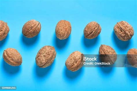 青い背景に全体の熟したクルミの行トップビュー おやつのストックフォトや画像を多数ご用意 おやつ オーガニック クルミ Istock