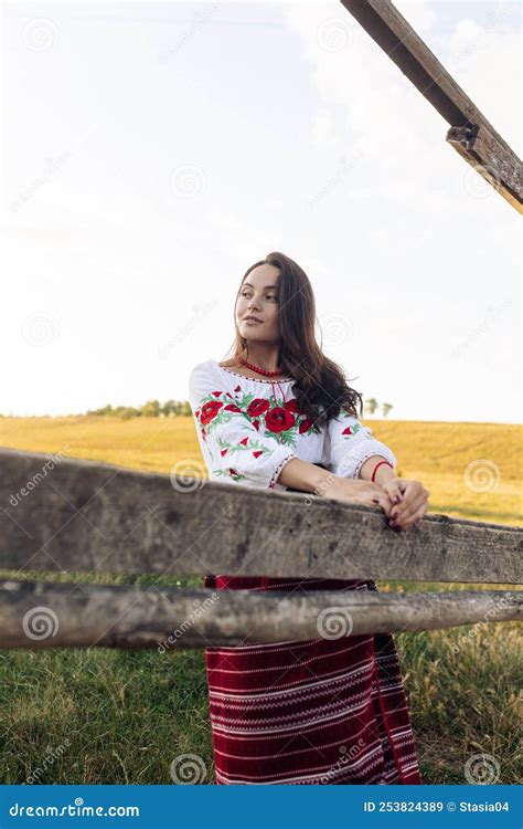 天色背景下，在草甸上的木篱笆旁，年轻的乌克兰女性站在传统的民族服装旁 库存图片 图片 包括有 字段 范围 253824389