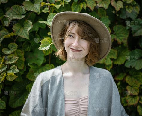 戴着帽子和披着斗篷的年轻女子。