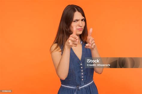 총 제스처 성가신 갈색 머리 여자 에 데님 드레스 가리키는 손가락 권총 에 카메라 위협 에 촬영 가리키기에 대한 스톡 사진 및