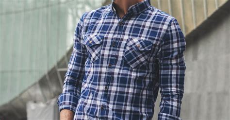 Man In Blue And White Plaid Shirt And Denim Jeans Standing On Concrete
