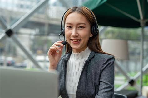 하이브리드 업무 공간 노트북과 귀 마이크를 가진 젊은 아시아 여성 성인 사업가가 카페에서 일합니다 18 19세에 대한 스톡 사진