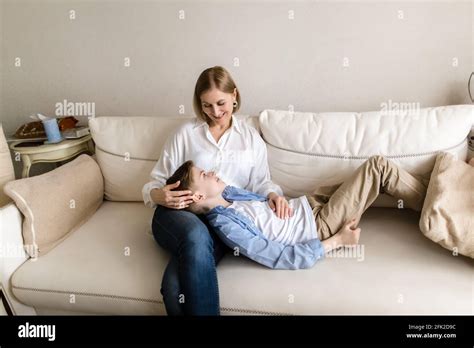 Teenager Lies On The Lap Of An Adult Woman She Strokes His Head Stock