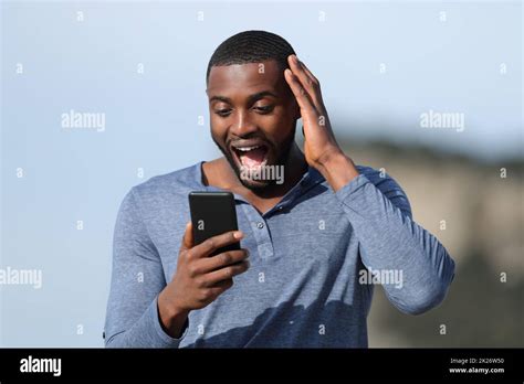 Amazed Man With Black Skin Checking Phone Outdoors Stock Photo Alamy