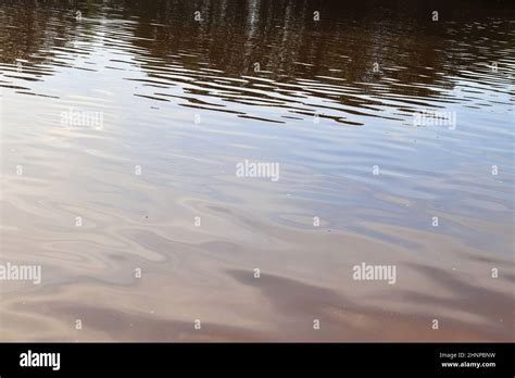 Detailed Close Up View On Water Surfaces With Waves And Ripples And The Sunlight Reflecting At