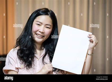 The Asian Woman Is Holding And Showing Empty White A4 Paper Portrait