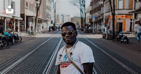 흰색 크루넥 티셔츠와 파란색 바지를 입은 남자가 도로에 서 있다 사진 Unsplash의 무료 회색 이미지