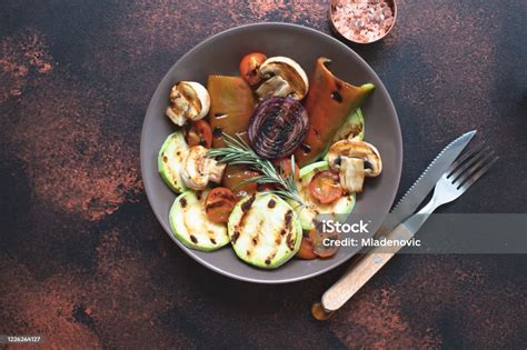 구운 채소는 어두운 빈티지 배경에 로즈마리와 바다 소금을 곁들인 접시에 담겨 제공됩니다 맨 위 보기 복사 공간 0명에 대한 스톡