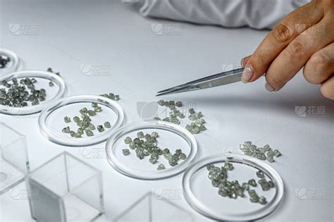 人工挑选钻石的过程。宝石按质量和重量分类，排列在玻璃杯中