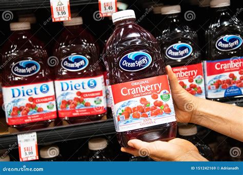 Shoppers Hand Holding A Plastic Bottle Of Ocean Spray Brand 100