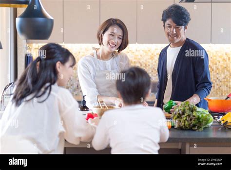 A Couple Standing In The Kitchen And A Brother And Sister Talking Stock