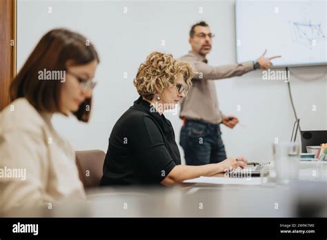 Multi Generational Business Professionals In A Boardroom Discussing
