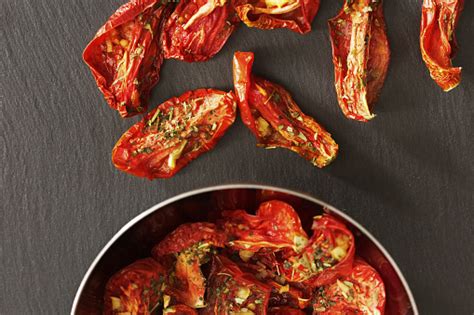 마늘과 어두운 표면에 이탈리아 향신료와 함께 햇볕에 말린 붉은 토마토를 슬라이스 볼 탑 아주 맛 있는 채식 음식입니다 건강한