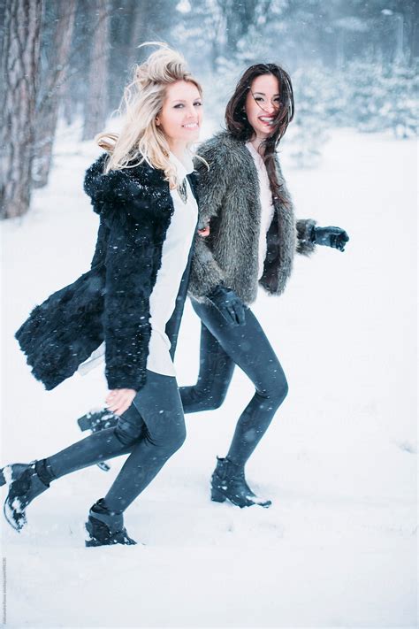 Two Beautiful Girlfriends Enjoy The Snow In Nature By Stocksy