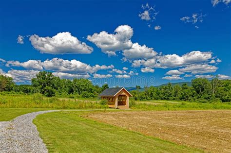 Curved Gravel Path Leading To Small Vermont Covered Bridge And Cumulus