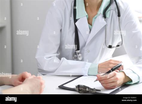 Il Medico E Il Paziente Seduto Alla Scrivania Vicino Alla Finestra In