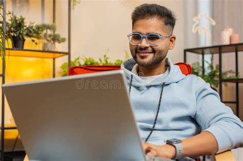 Young Man Freelancer Sitting On Chair Working On Laptop Pc Browsing