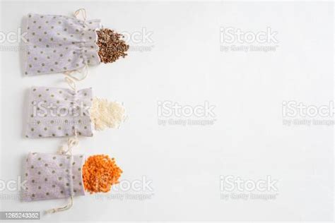 흰색 콘크리트 배경에 흩어져 캔버스 가방에 다양한 시리얼 메밀 쌀과 렌즈콩 천연 채식 식물성 단백질 텍스트를 위한 장소가 있는